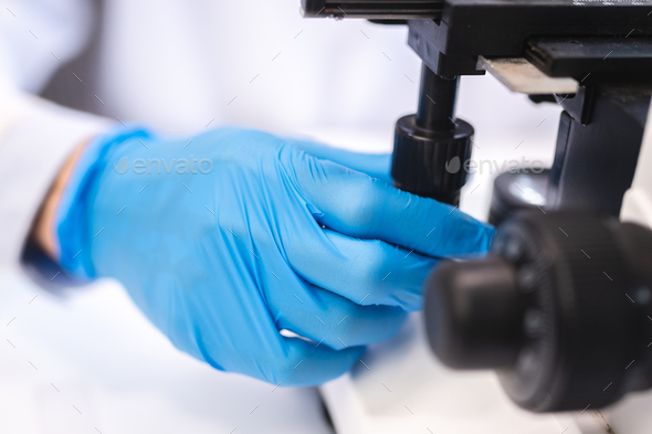Scientist analyzing microscope slide at laboratory, technician ...