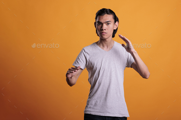 Serious young asian man standing in karate fighting pose Stock Photo by ...