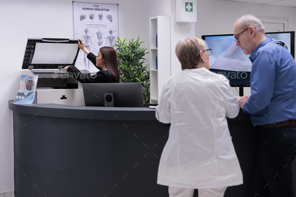 Worker using copy printer at reception desk Stock Photo by DC_Studio