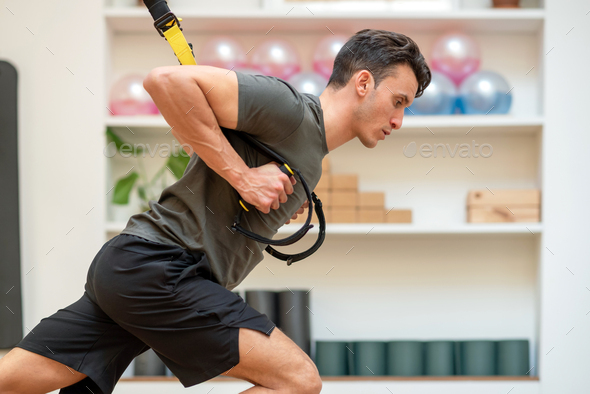 Athletic sportsman doing exercise on TRX ropes in gym Stock Photo by ...