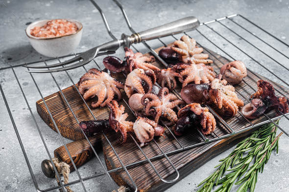 Grilled baby mini octopuses on a grill. Gray background. Top view Stock ...