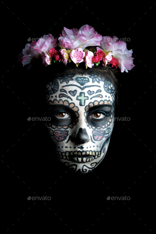 Woman's face painted as Catrina on black background, day of the dead ...