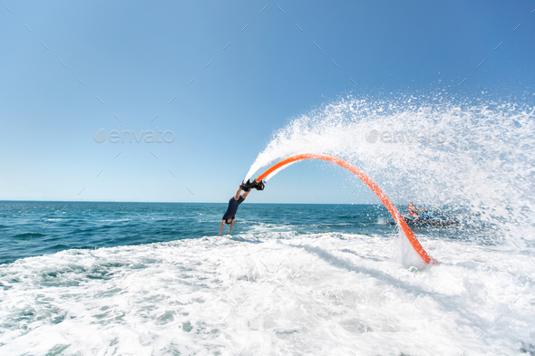 Water extreme sport. The guy is flying at the aquatic flyboard. A lot ...
