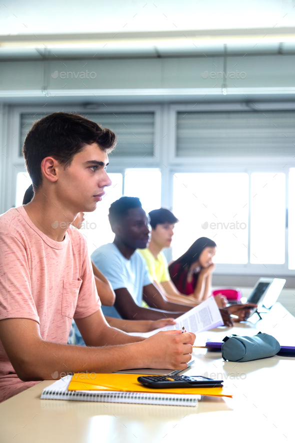 College male student listening to teacher. Multiracial high school ...