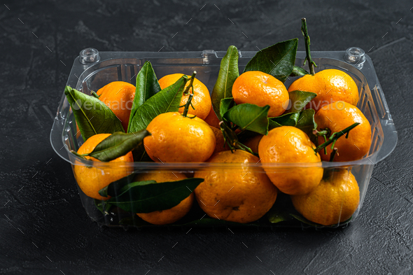 Tangerines, mandarines in a plastic container, box. Black background ...