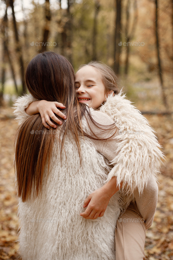 Portrair of mother and her daughter hugging outdoors Stock Photo by prostooleh