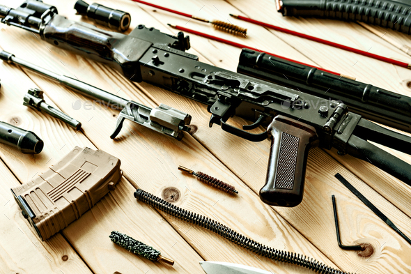 Disassembled rifle with cleaning tools on table of weapons workshop ...