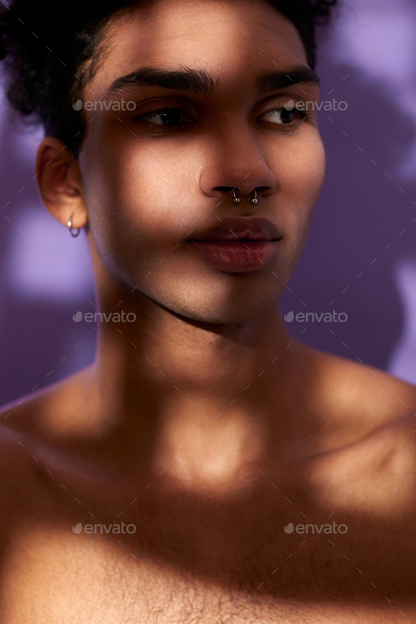Verticale portrait of sensual young man in shadows. Sensitive hispanic ...