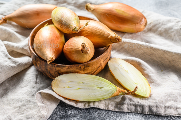 Raw Shallot onions, cut in two halves. Gray background. Top view Stock ...