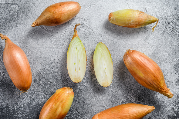 Raw Shallot onions, cut in two halves. Gray background. Top view Stock ...