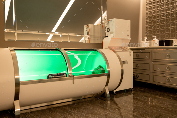 Man lying in oxygen capsule in medical office Stock Photo by RossHelen