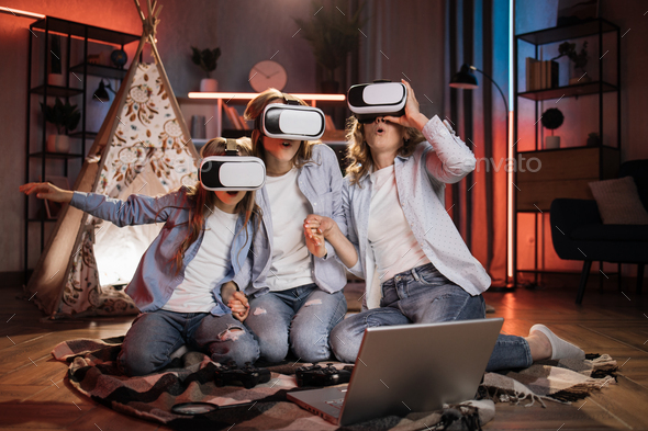Caucasian woman and female children sitting outside teepee tent and ...