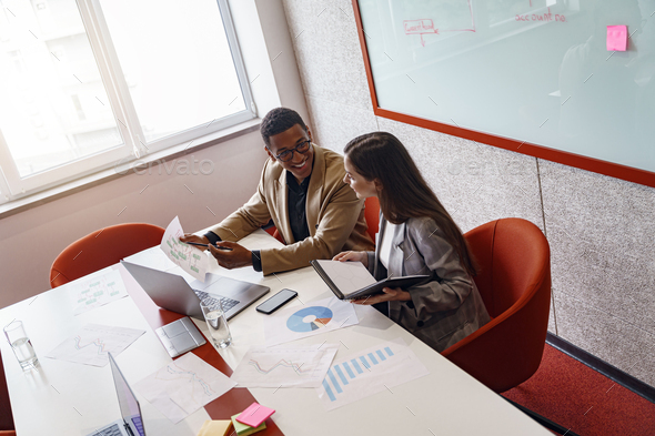 Smiling coworkers cooperating and working together at coworking space ...