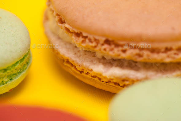 Close up big macaroon caramel flavour next to little macaroons over ...