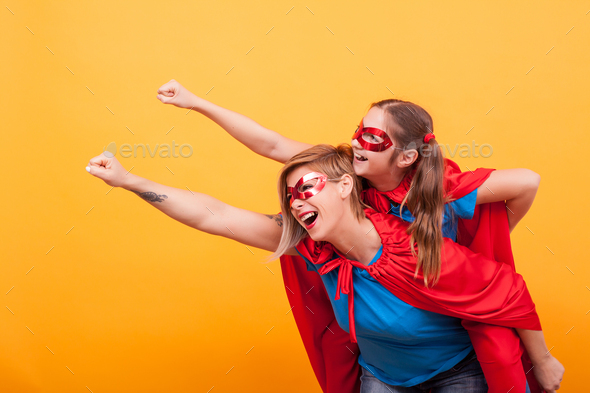 Beautiful mother and her cute little girl playing together dressed like ...