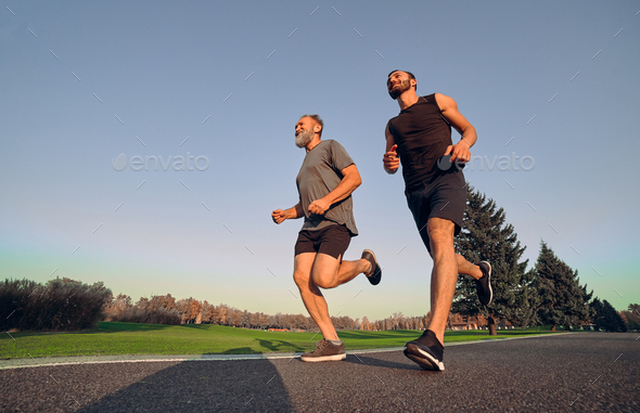 The old and young sportsmen running on the alley. Stock Photo by artemp3