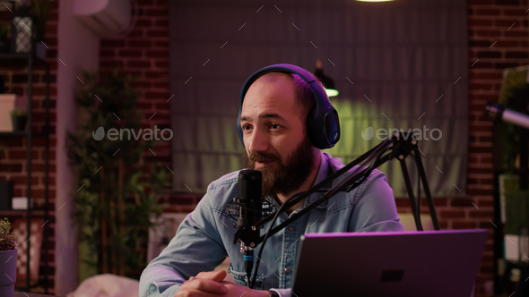 Male content creator recording vlog using digital video camera while ...