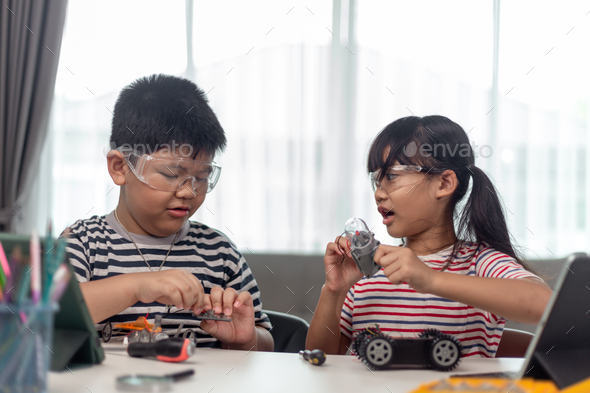 two Asian children having fun learning coding together, learning ...