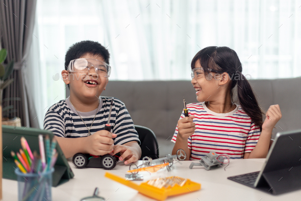 two Asian children having fun learning coding together, learning ...