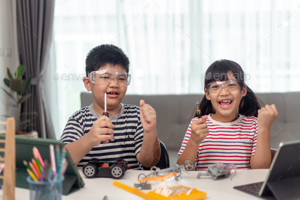 two Asian children having fun learning coding together, learning ...