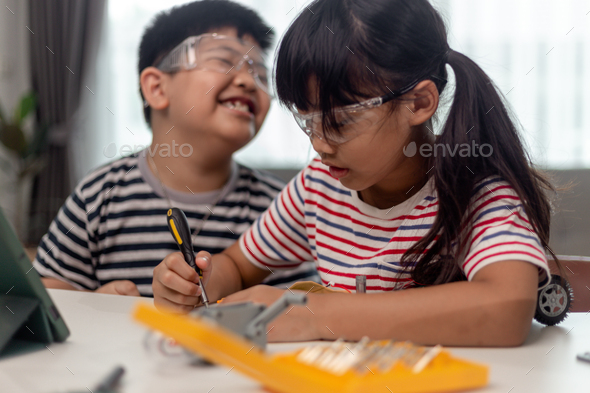 two Asian children having fun learning coding together, learning ...
