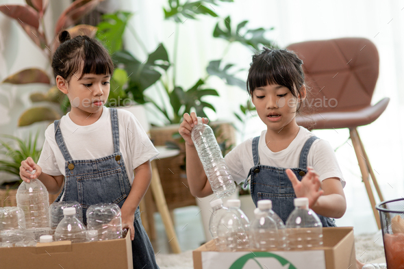 Smiling children having fun while segregating plastic bottles and paper ...