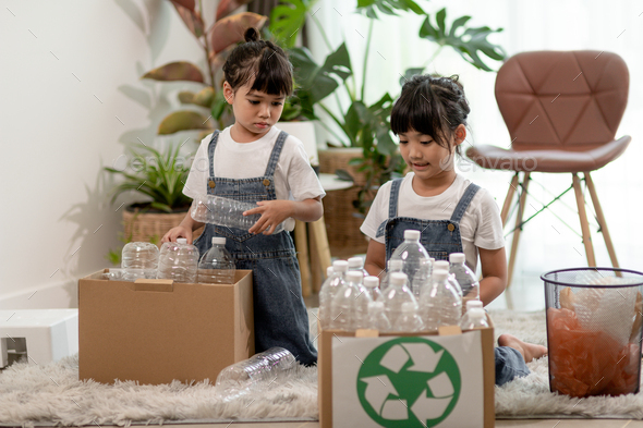Smiling children having fun while segregating plastic bottles and paper ...