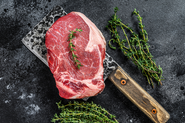 Raw beef striploin on the bone meat steak. Black ground. Top view Stock ...