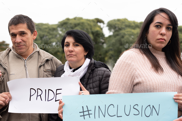A group of people holding inclusión and pride signs as a protest. LGBT ...