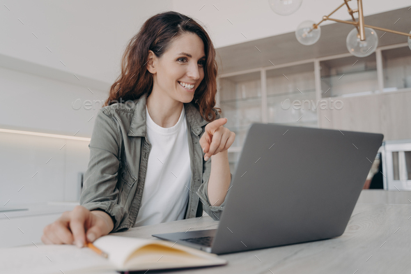 Happy girl student learning online by video call point to laptop screen ...