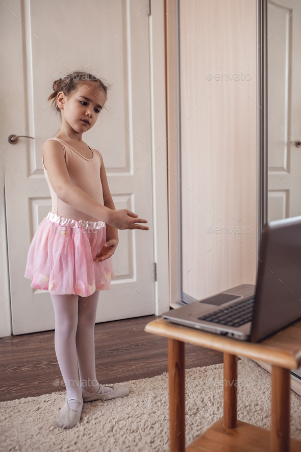 Young ballerina practicing classic choreography during online class in ...