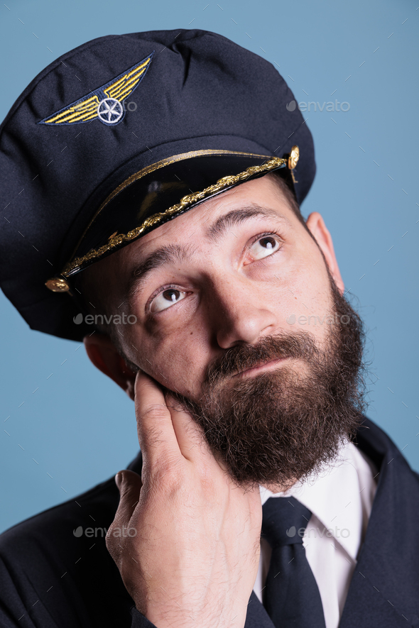Thoughtful airline pilot in uniform looking upwards, face closeup Stock ...