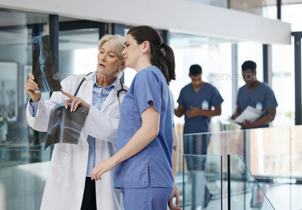 Solving problems together. Shot of two female doctors examining an x ...