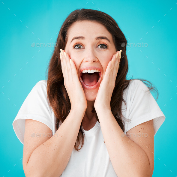 Studio portrait of an attractive young woman looking surprised against ...