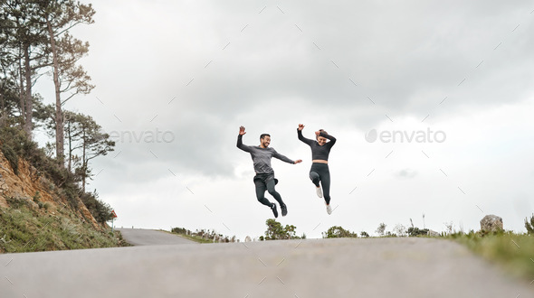 We did it. Full length shot of two young athletes jumping for joy after ...