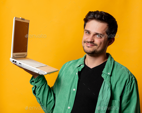 programmer guy in green shirt hold laptop computer in hand Stock Photo ...