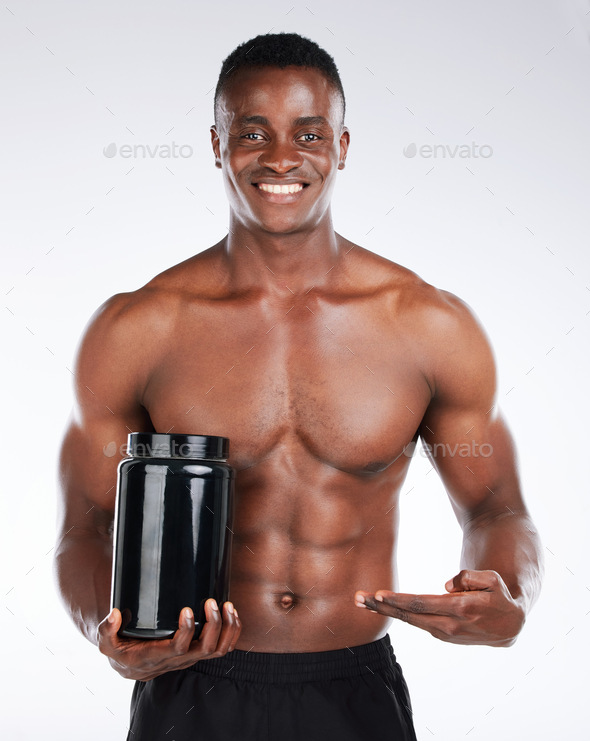 Shot of a handsome young man standing alone in the studio and holding a ...