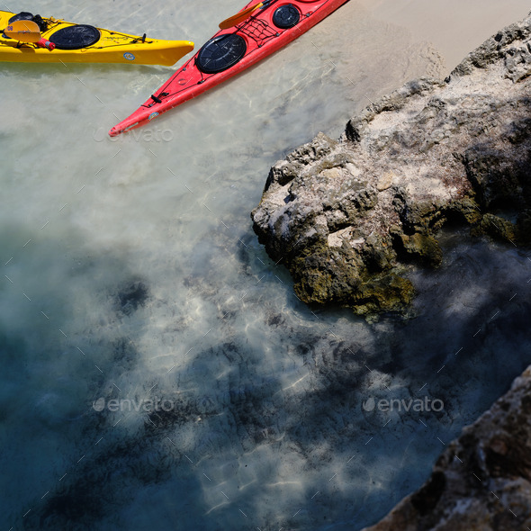 Yellow and red sea kayaks ready on the sea by the rock Stock Photo by ...