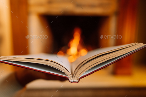 Stunning view of open book against burning fire from fireplace ...