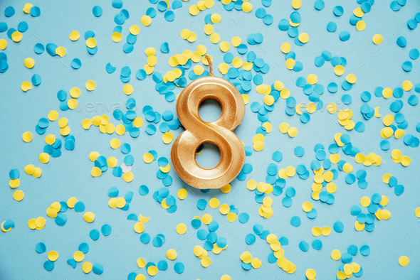 Number 8 eight golden celebration birthday candle on yellow and blue ...