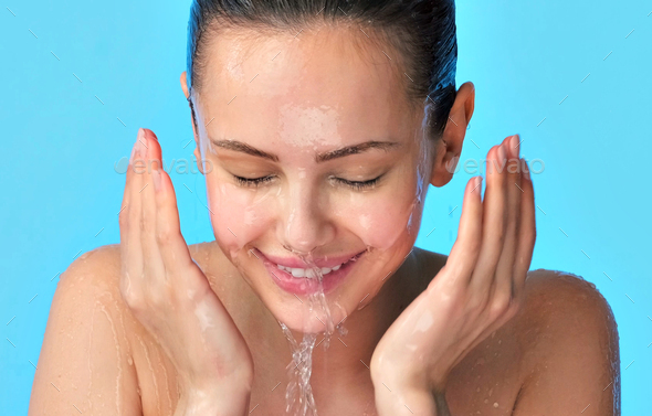 Woman washing her clean face with water. Closeup face of an Young girl ...