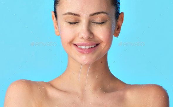 Female face with water on it. Young cheerful girl with water running ...