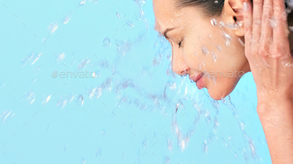 Woman washing her clean face with water. Closeup face of an Young girl ...