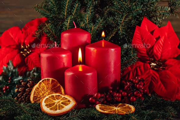 Two burning Red advent candles in advent wreath decoration on wooden ...