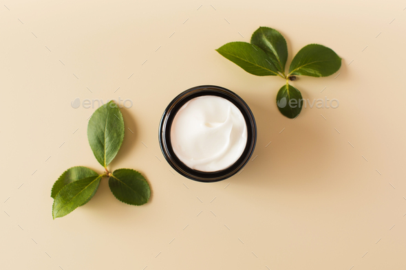 An open jar with cosmetics, a white moisturizer with a natural ...