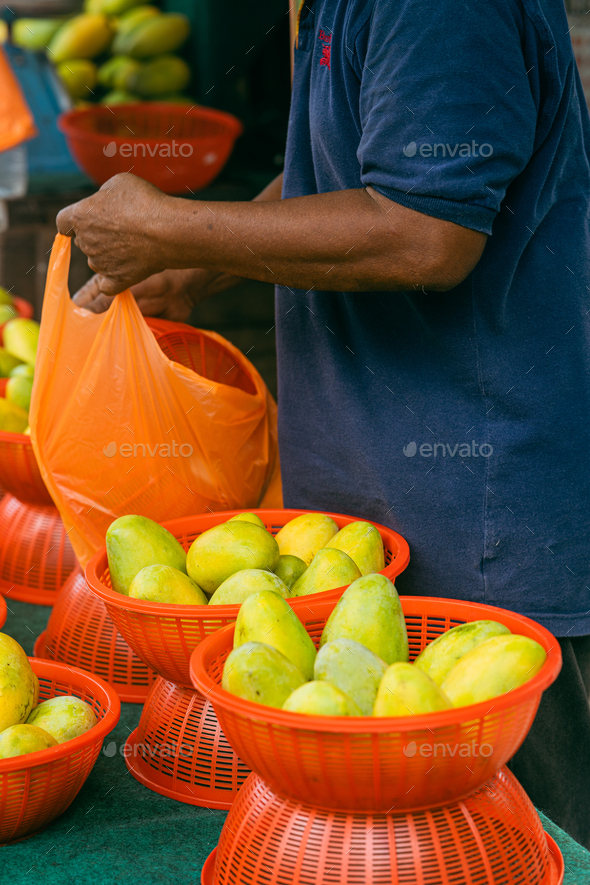 Selling fresh mangoes at the stall. Stock Photo by ellinnur | PhotoDune