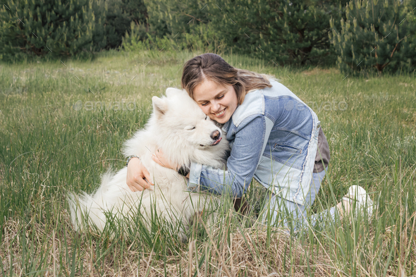 Woman hugging her dog samoyed Stock Photo by gilitukha | PhotoDune