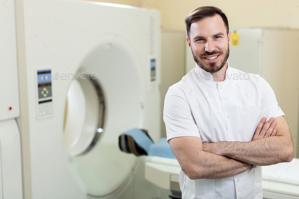 Smiling male radiologist in front of MRI scanner at clinic. Stock Photo ...