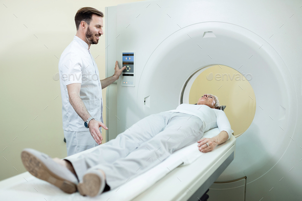 Happy male radiologist and patient during CT scan examination in the ...
