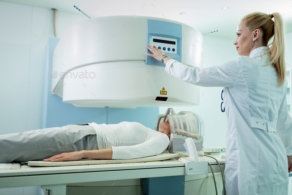 Female technician starting MRI scan of a patient at clinic. Stock Photo ...